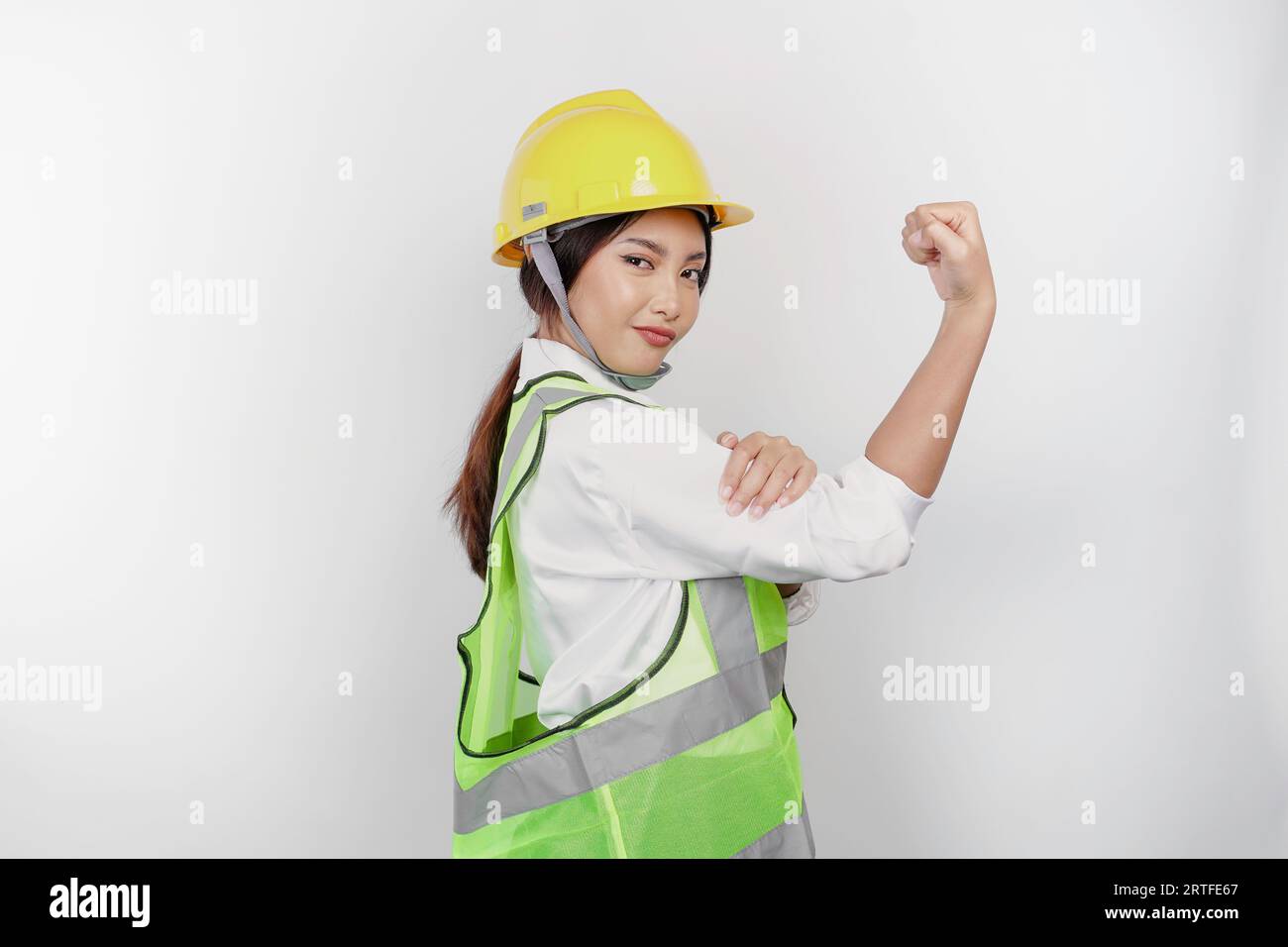 A portrait of Asian woman labor wears safety helmet and vest, showing ...