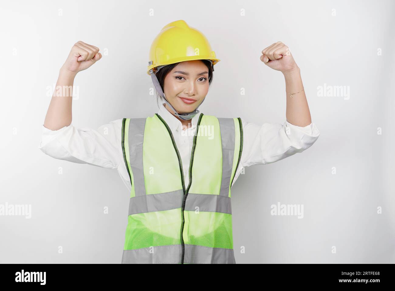 A portrait of Asian woman labor wears safety helmet and vest, showing ...