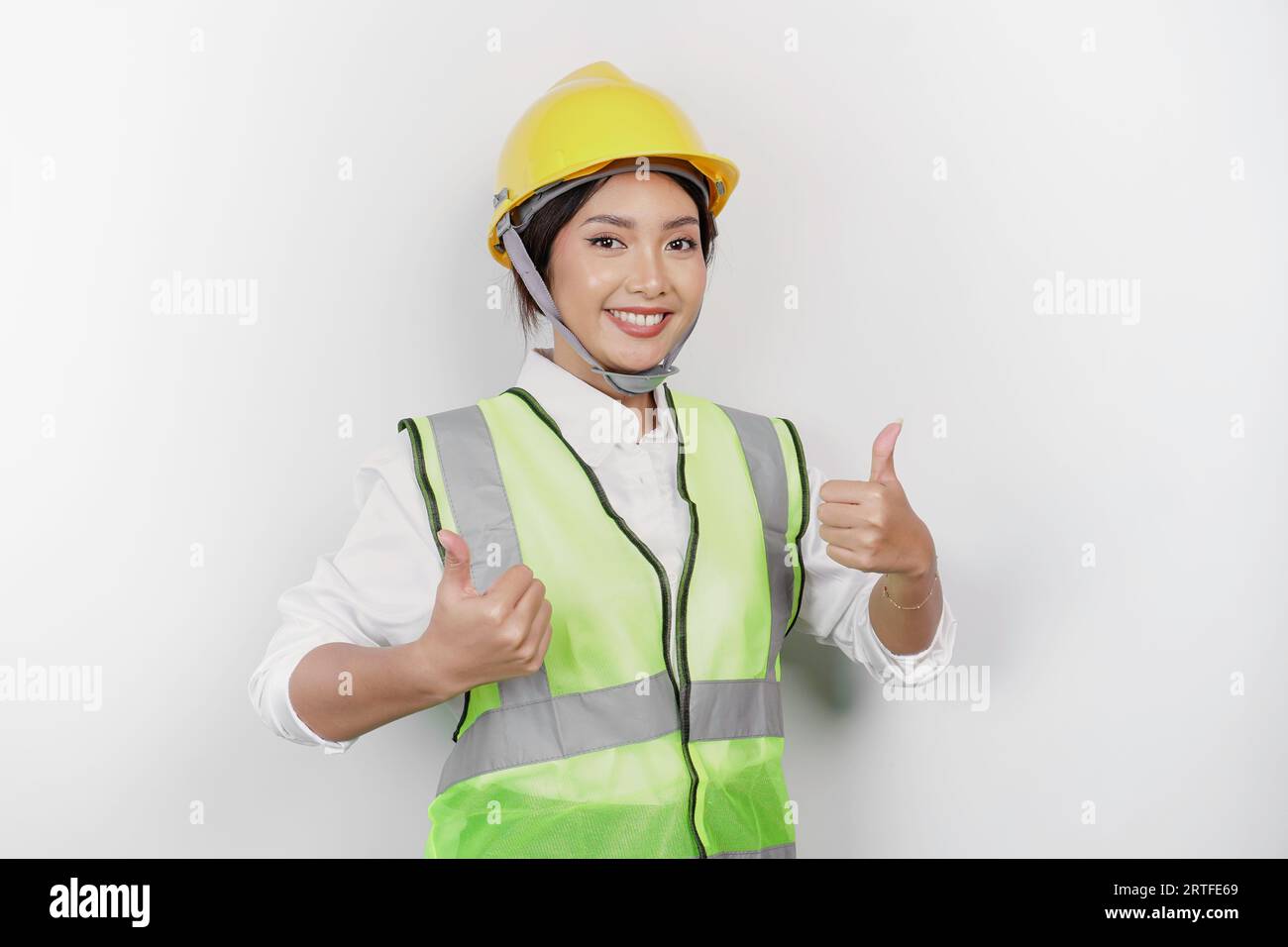 Excited Asian woman labor wearing safety helmet and vest gives thumbs ...