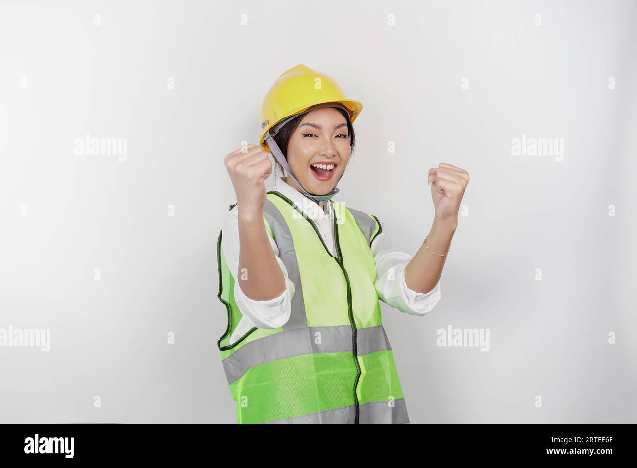 A successful young woman labor is wearing safety helmet and vest ...