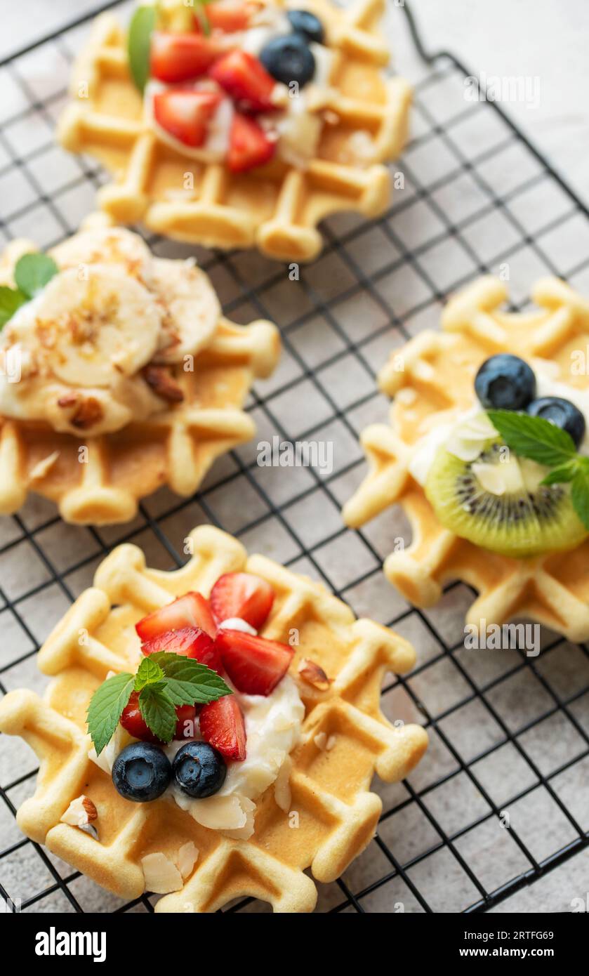 Freshly baked waffles with strawberries and blueberries on a concrete ...
