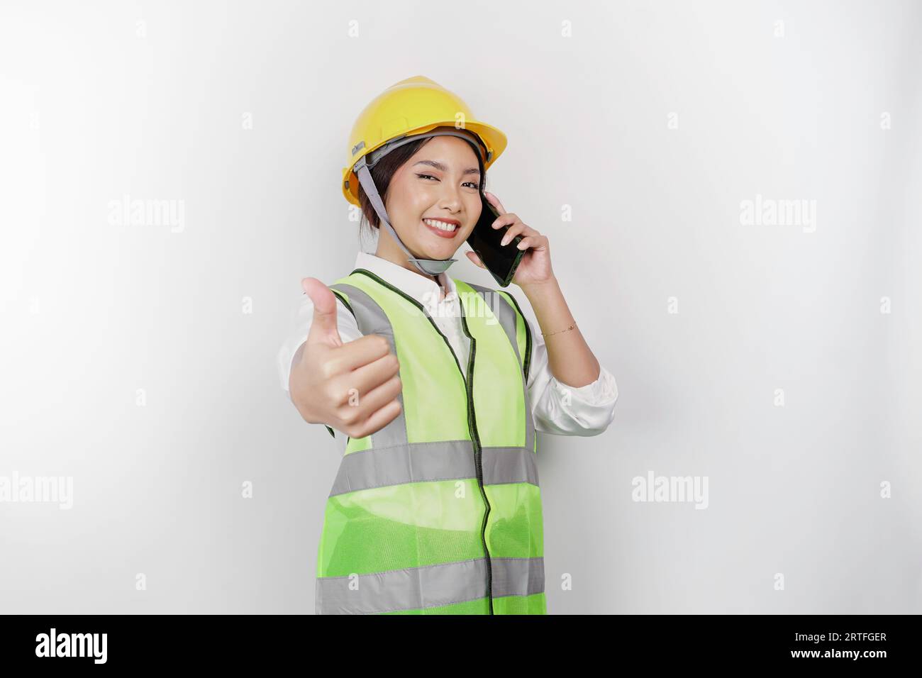 Excited Asian woman labor wearing safety helmet and vest gives thumbs ...