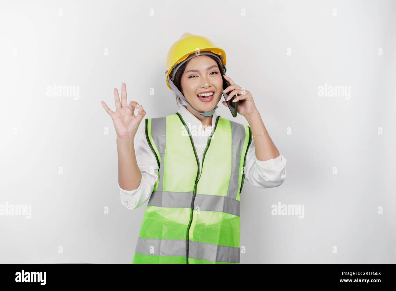 Excited Asian woman labor wearing safety helmet and vest gives thumbs ...