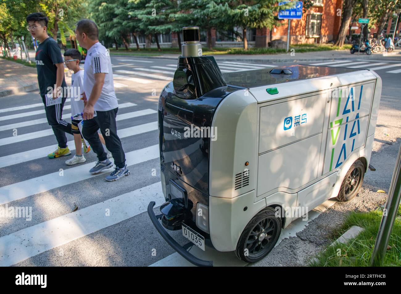 Unmanned express vehicles shuttle through a college campus in Zhengzhou ...