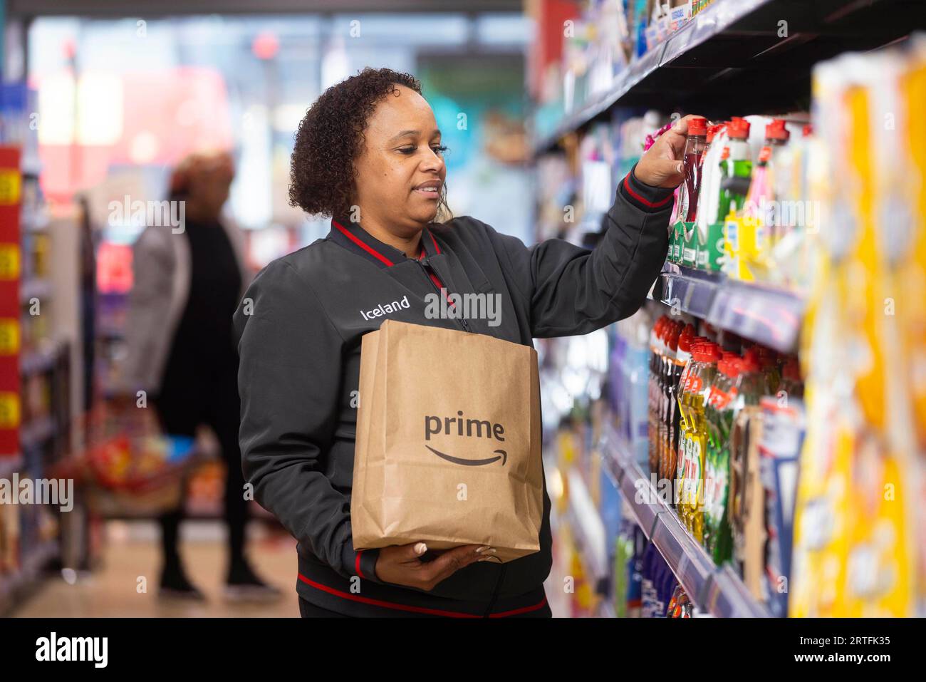 EDITORIAL USE ONLY A retail assistant packs Iceland groceries into an ...