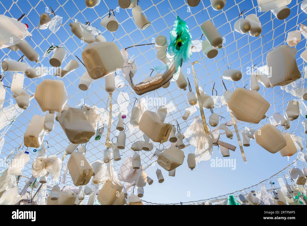 Plastic containers in fishing net against blue sky - concept of garbage ...