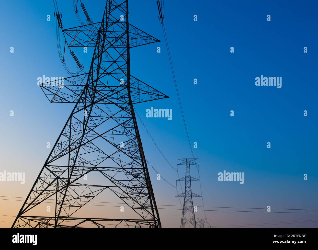 Electric transmission towers over blue sky Stock Photo - Alamy