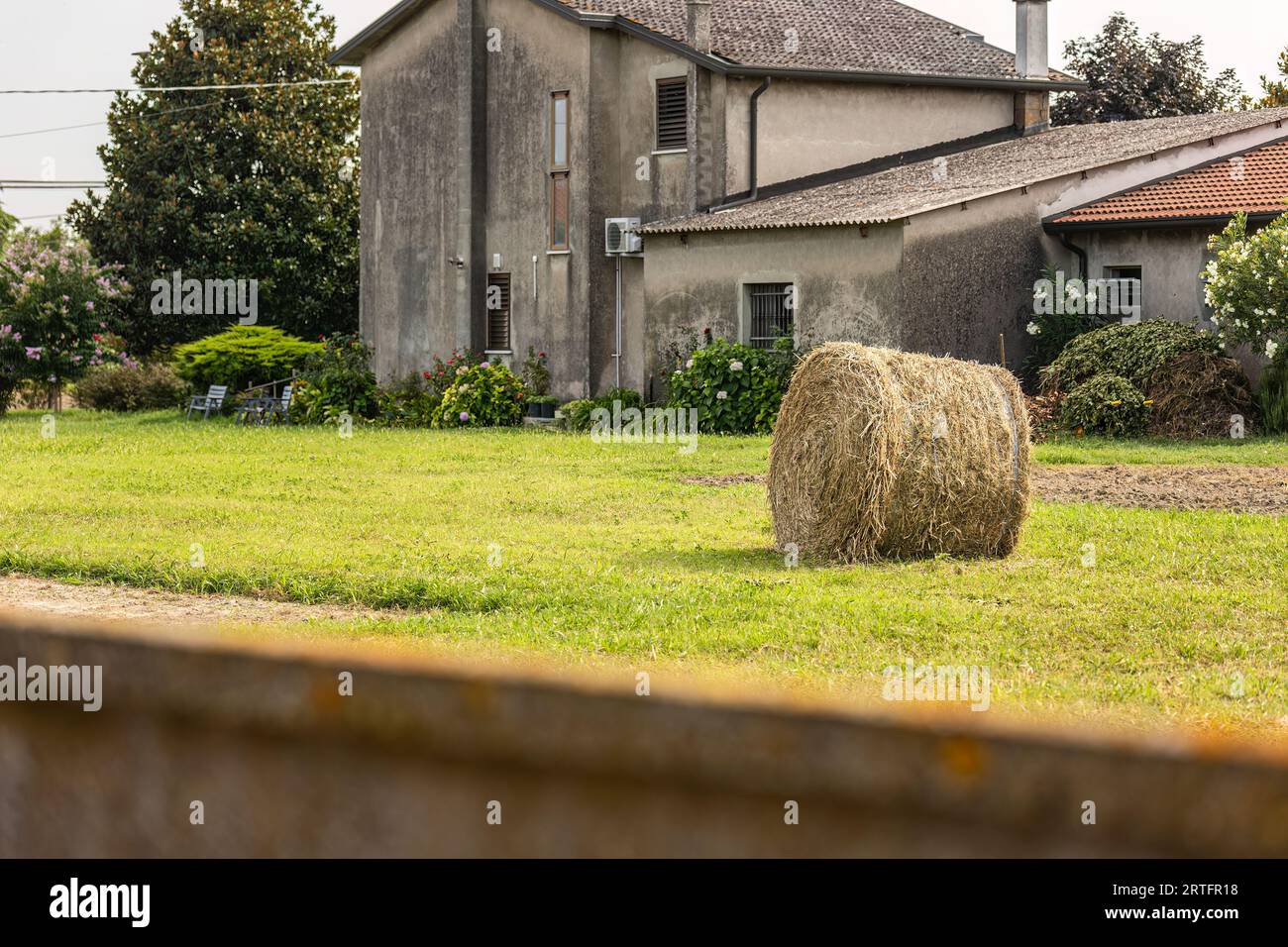 Rustic country house showcasing a large hay bale in the front ...