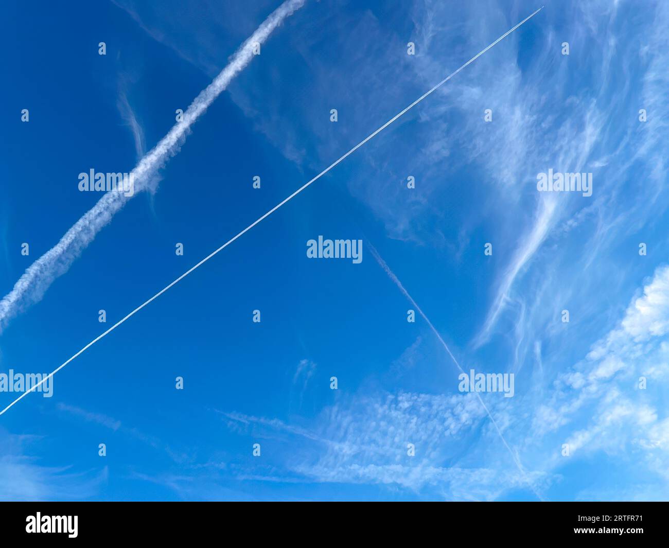 Multiple chemtrails streak across a clear blue sky, sparking ... Multiple chemtrails streak across a clear blue sky, sparking ...