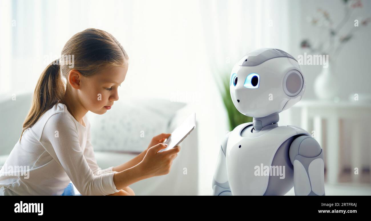 A cute girl is playing with a robot. The concept of future training ...