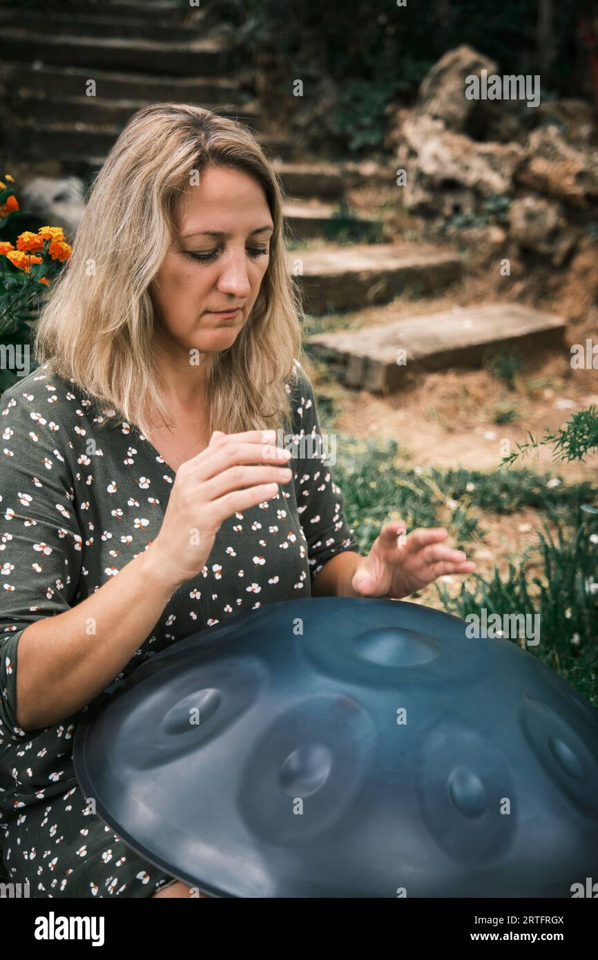 a woman plays on handpan or hang Stock Photo - Alamy