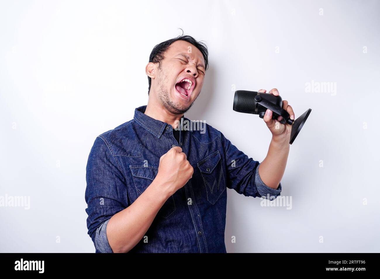 Portrait of carefree Asian man, having fun karaoke, singing in ...