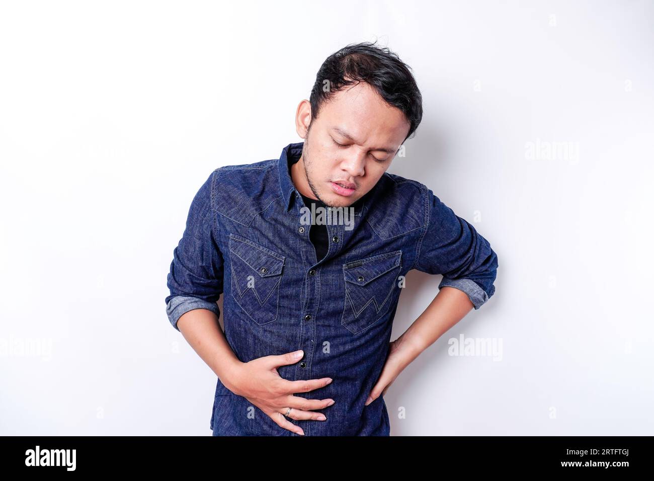 Photo of young unwell sick ill man hold hand on stomach suffers pain ...