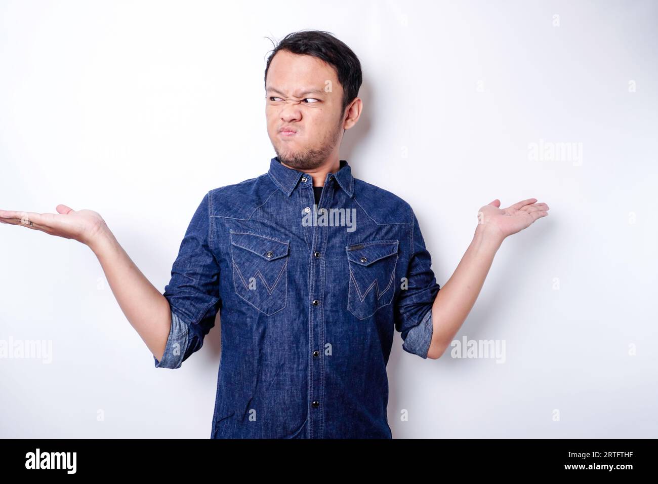 A portrait of an Asian man wearing a blue shirt looks so confused ...