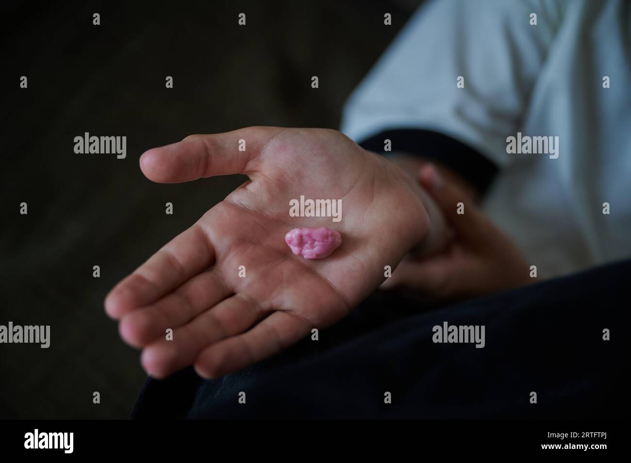 Berlin, Germany. 26th Aug, 2023. A child holds a chewed gum in his hand ...