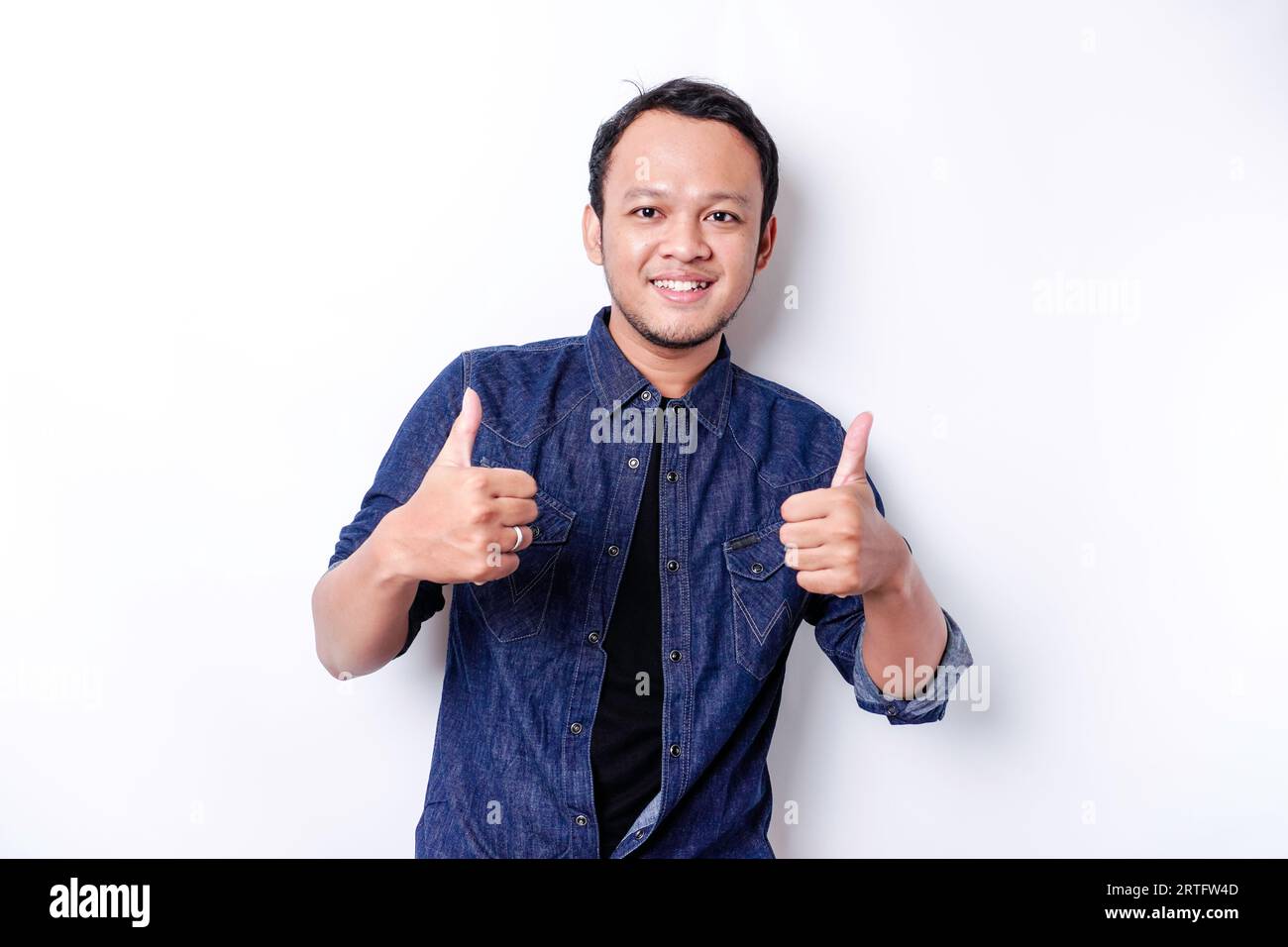 Excited Asian man wearing blue shirt gives thumbs up hand gesture of ...