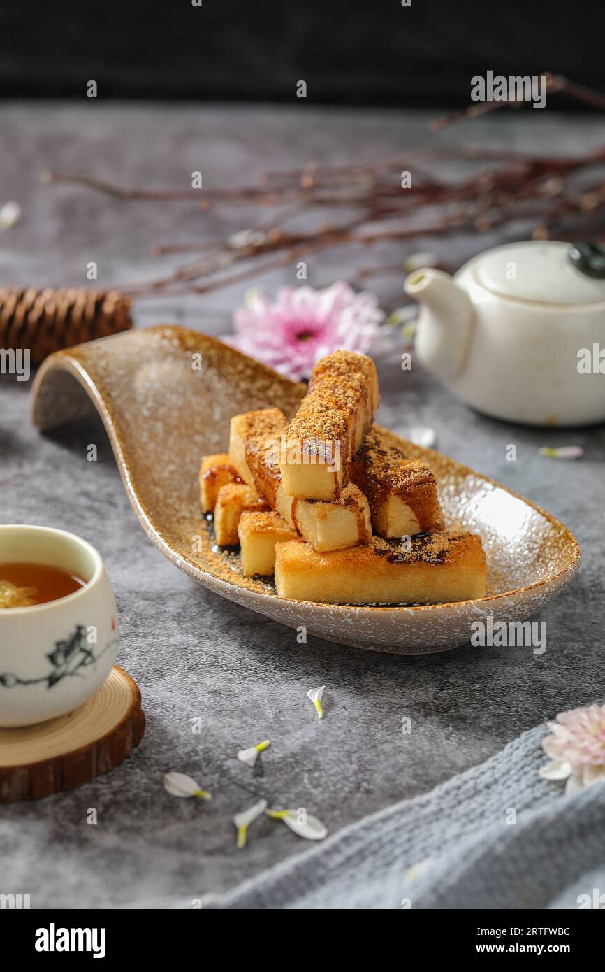 A plate of traditional Sichuan snacks, Brown sugar glutinous rice cake ...