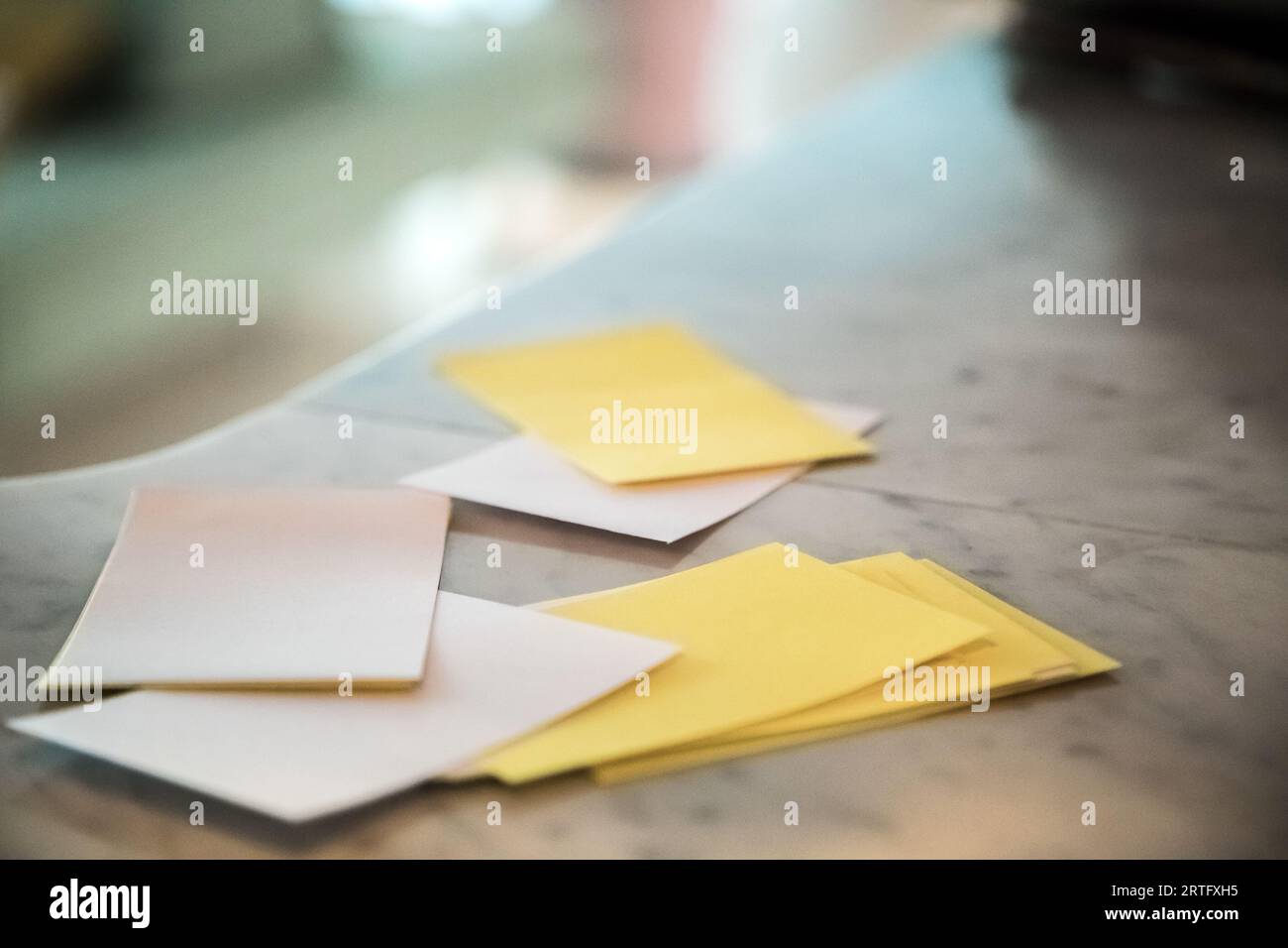 Blank white and yellow sheets of paper spread out on top of a flat ...