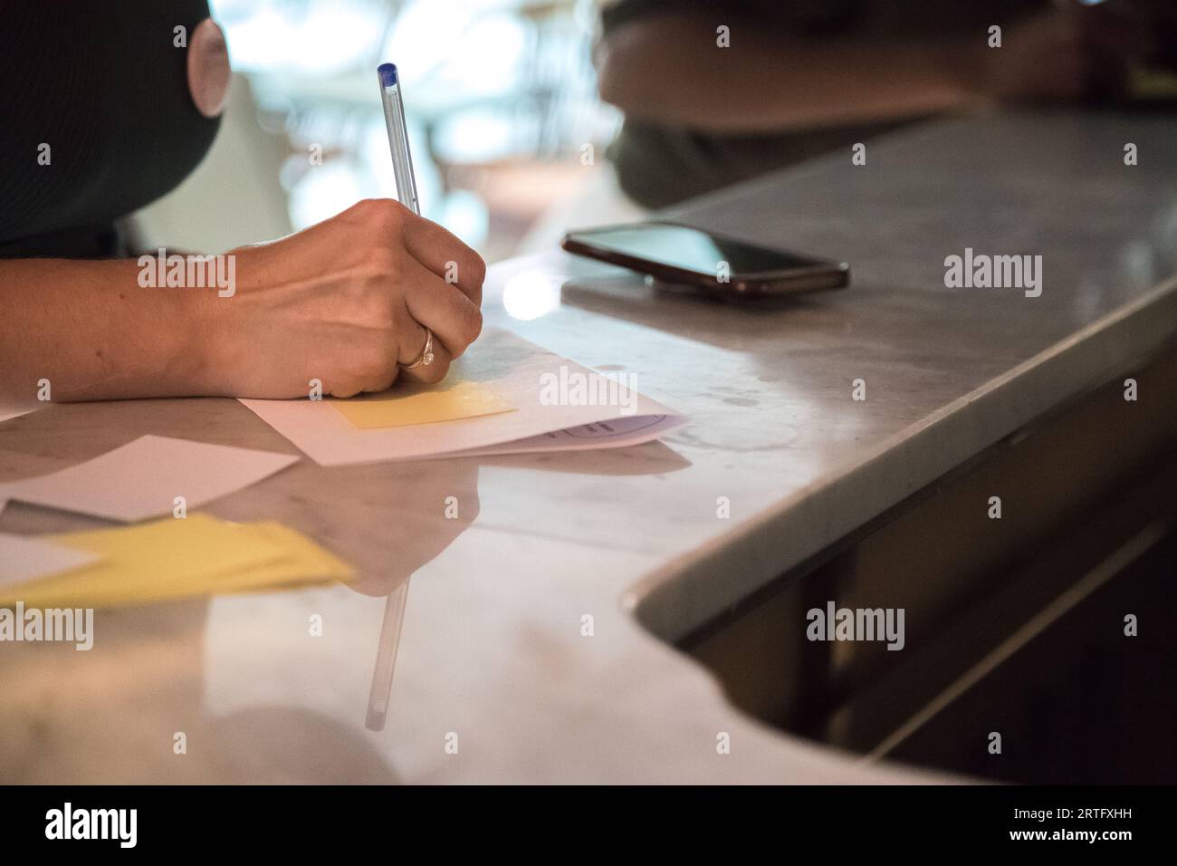 Woman's hand holding a pen and writing a message on a paper. Smart ...