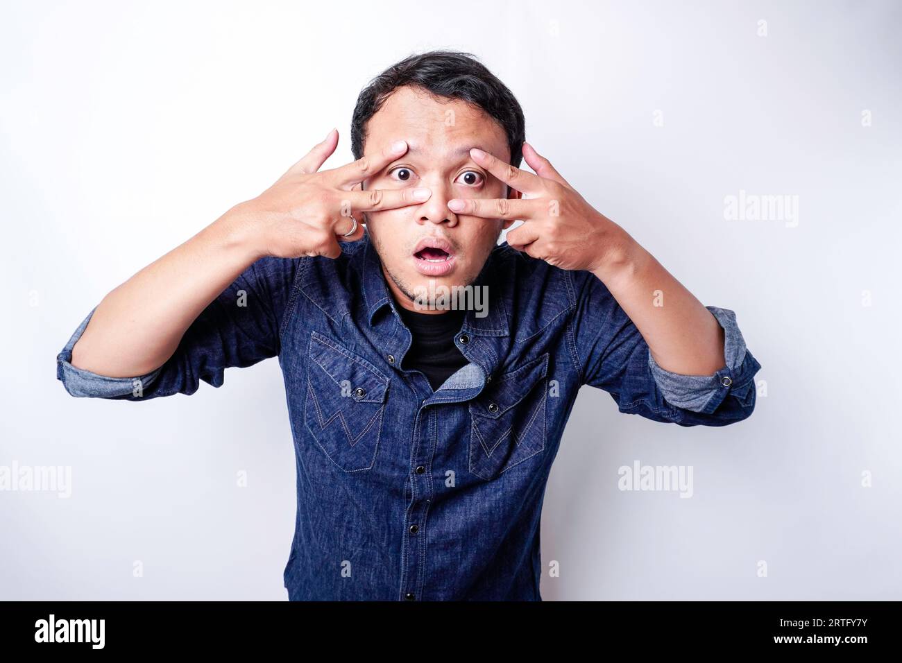 Funny obvious peeking Asian man in blue shirt isolated on white ...