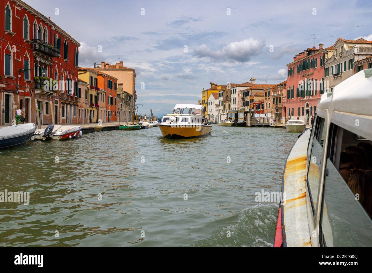 Venice, Italy - August 9, 2023; Perspective View of Venetian houses and boats along the canal ...