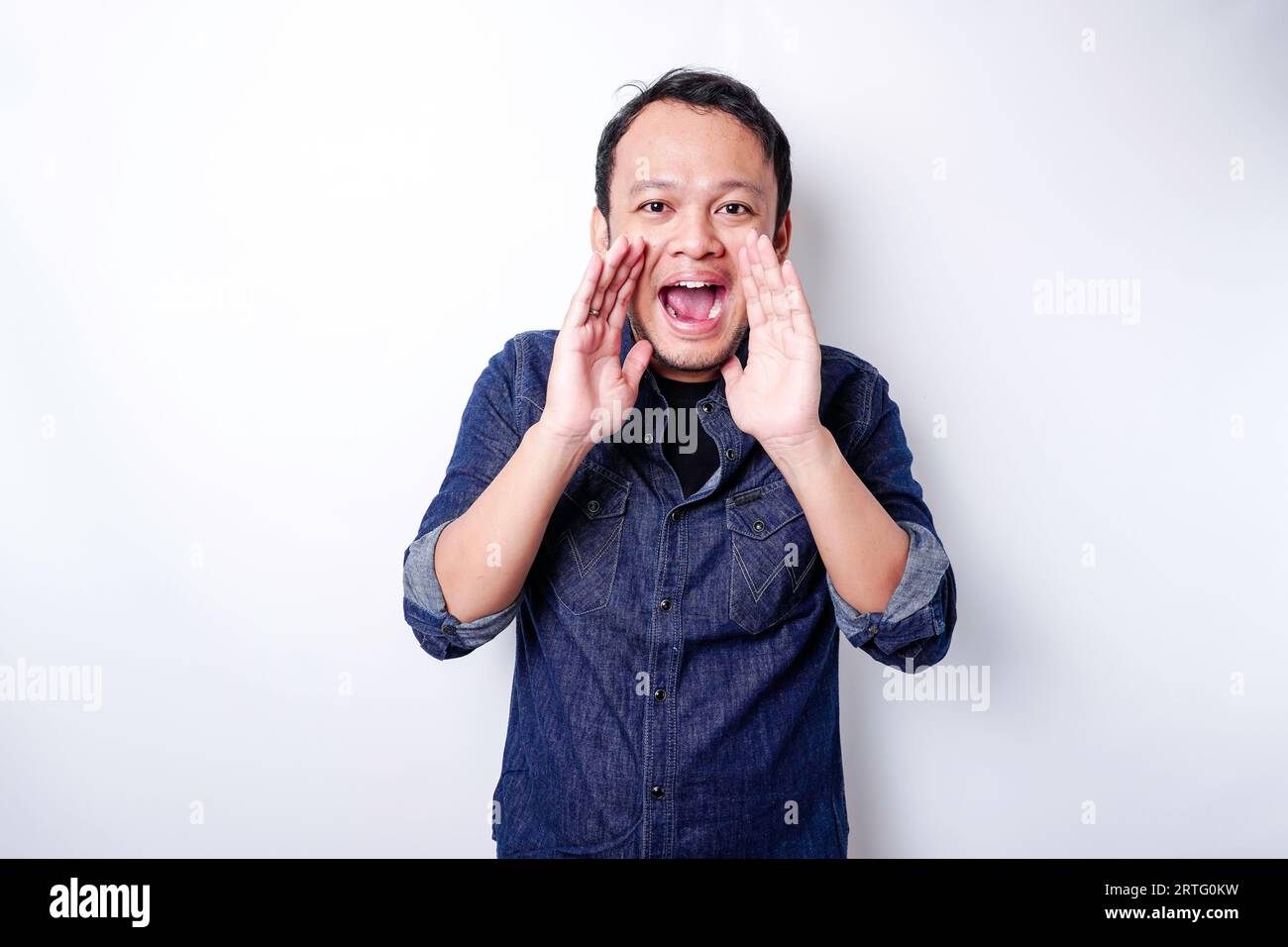 Young handsome man wearing a blue shirt shouting and screaming loud ...