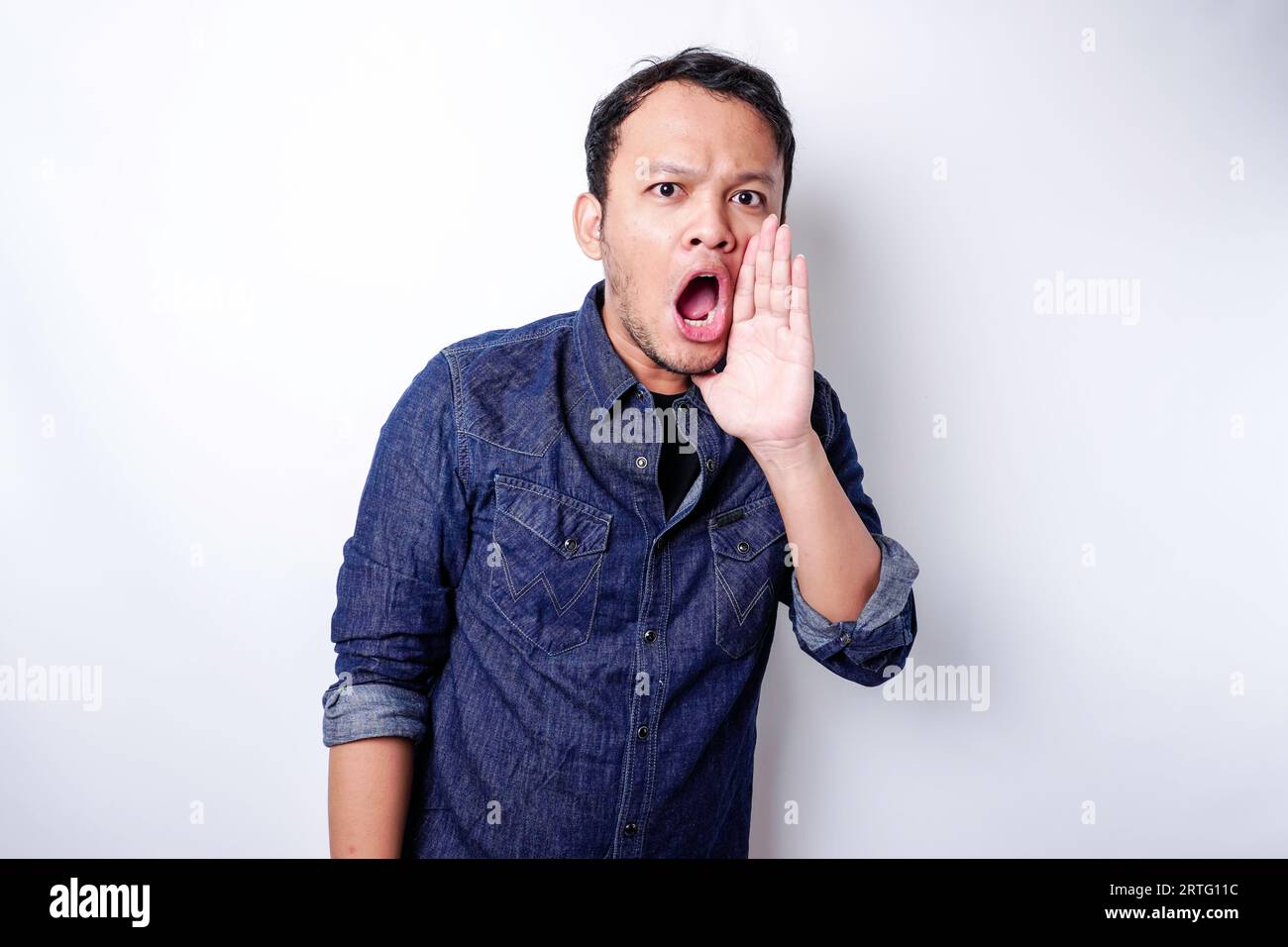 Young handsome man wearing a blue shirt shouting and screaming loud ...
