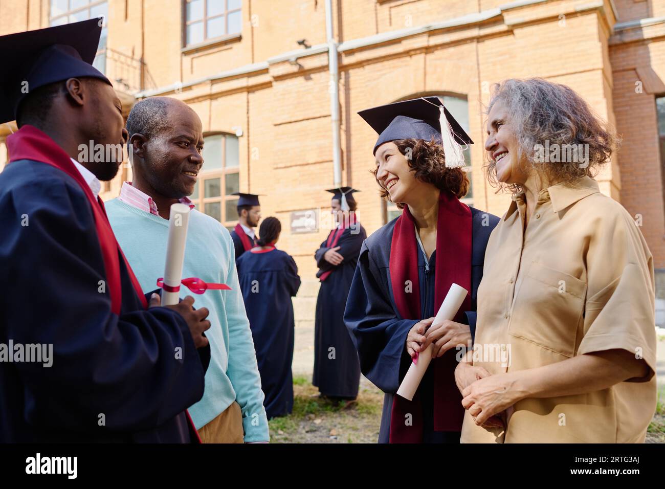 Parents congratulating their children with graduation of university ...