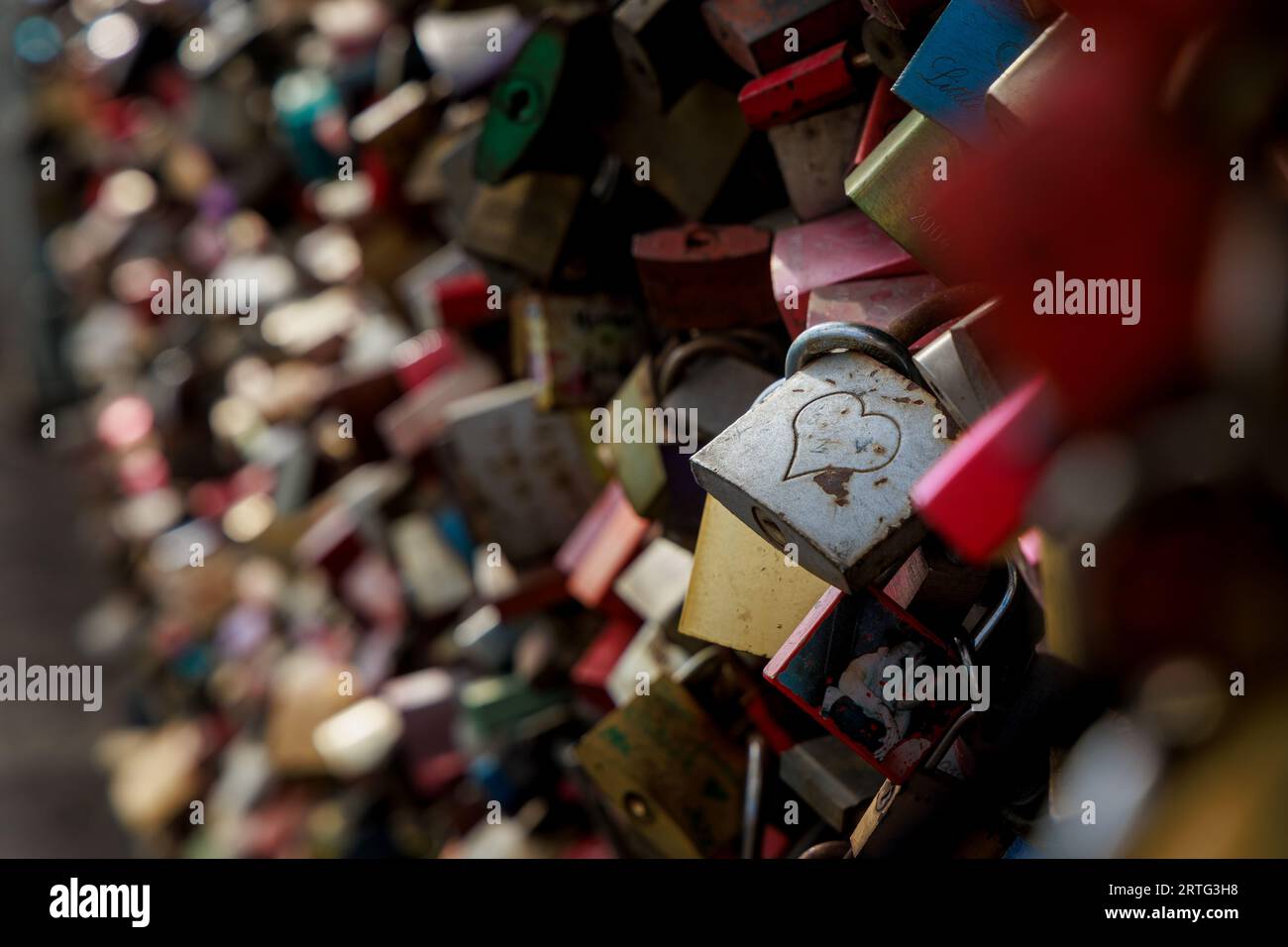 A collection of multiple padlocks hanging from a wall, each secured ...