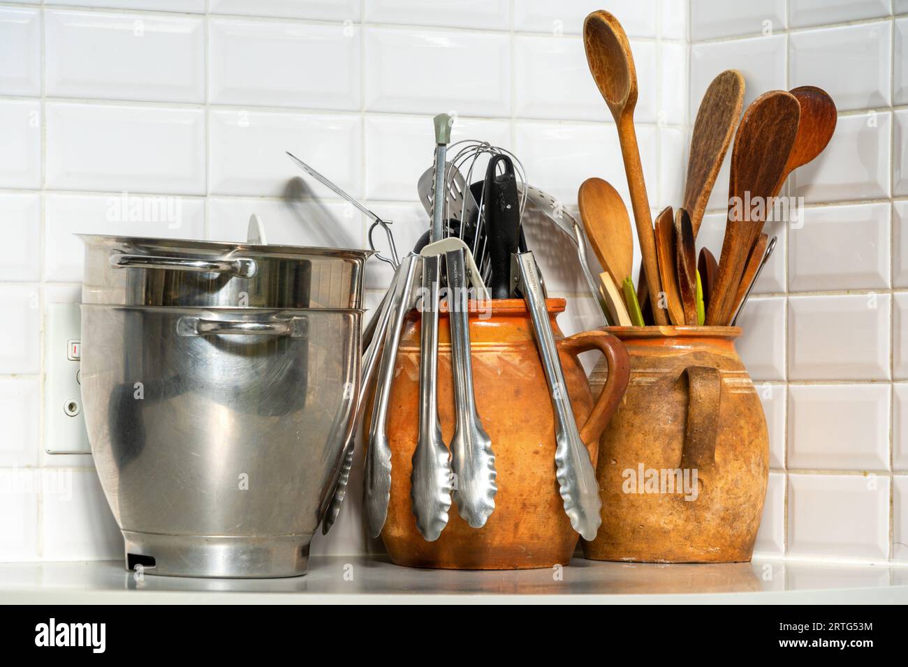 variety of cooking utensils stacked in clay pots ready for kitchen use ...