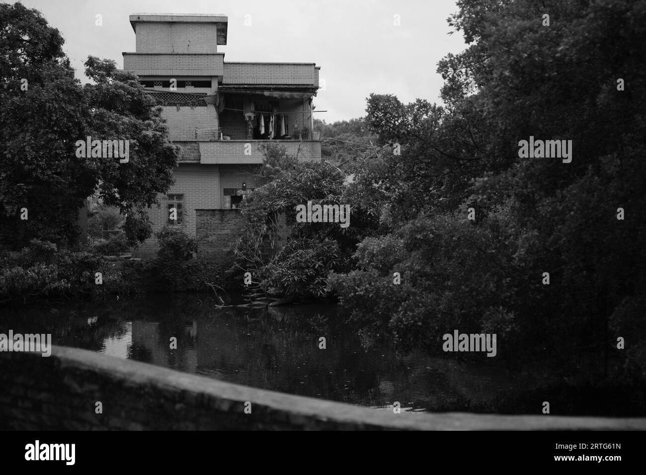 A majestic two-story house situated on the banks of a tranquil river in ...