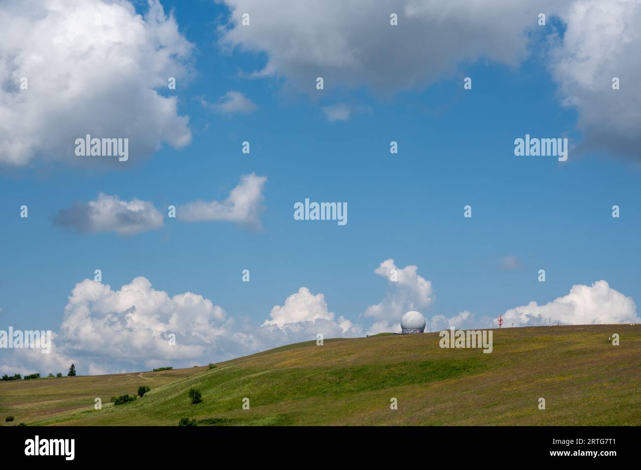 Radome (antenna dome) on the Wasserkuppe with a green meadow and blue ...