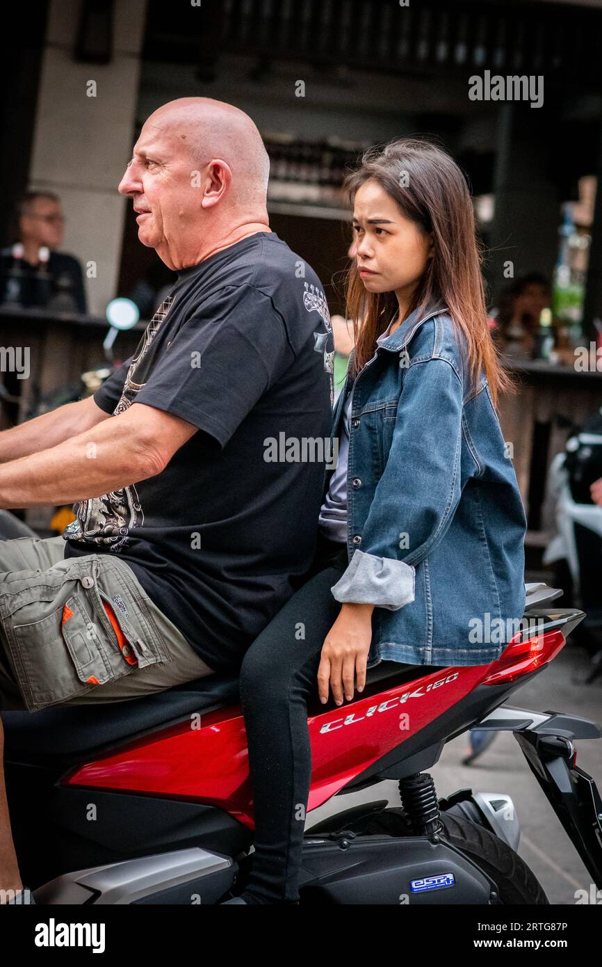 Local Thai people, tourists and residents rush past the busy junction ...