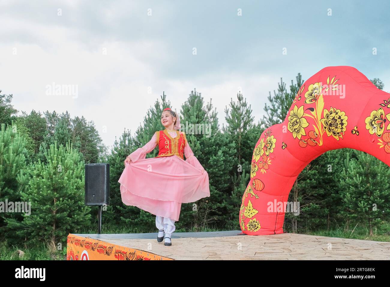 Sweet young smiling Asian girl in skullcap and traditional ethnic Tatar ...