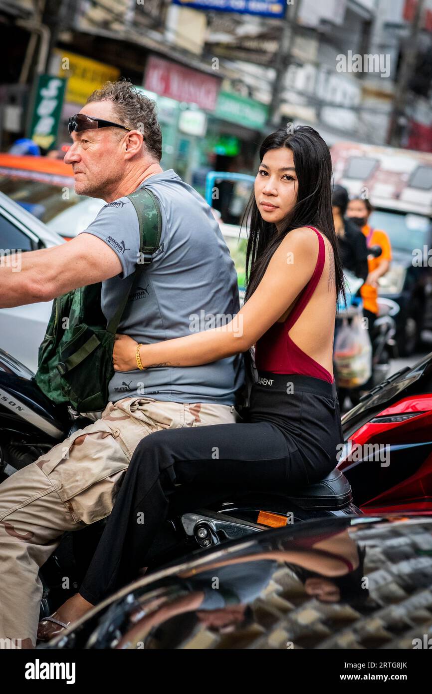 Local Thai people, tourists and residents rush past the busy junction ...