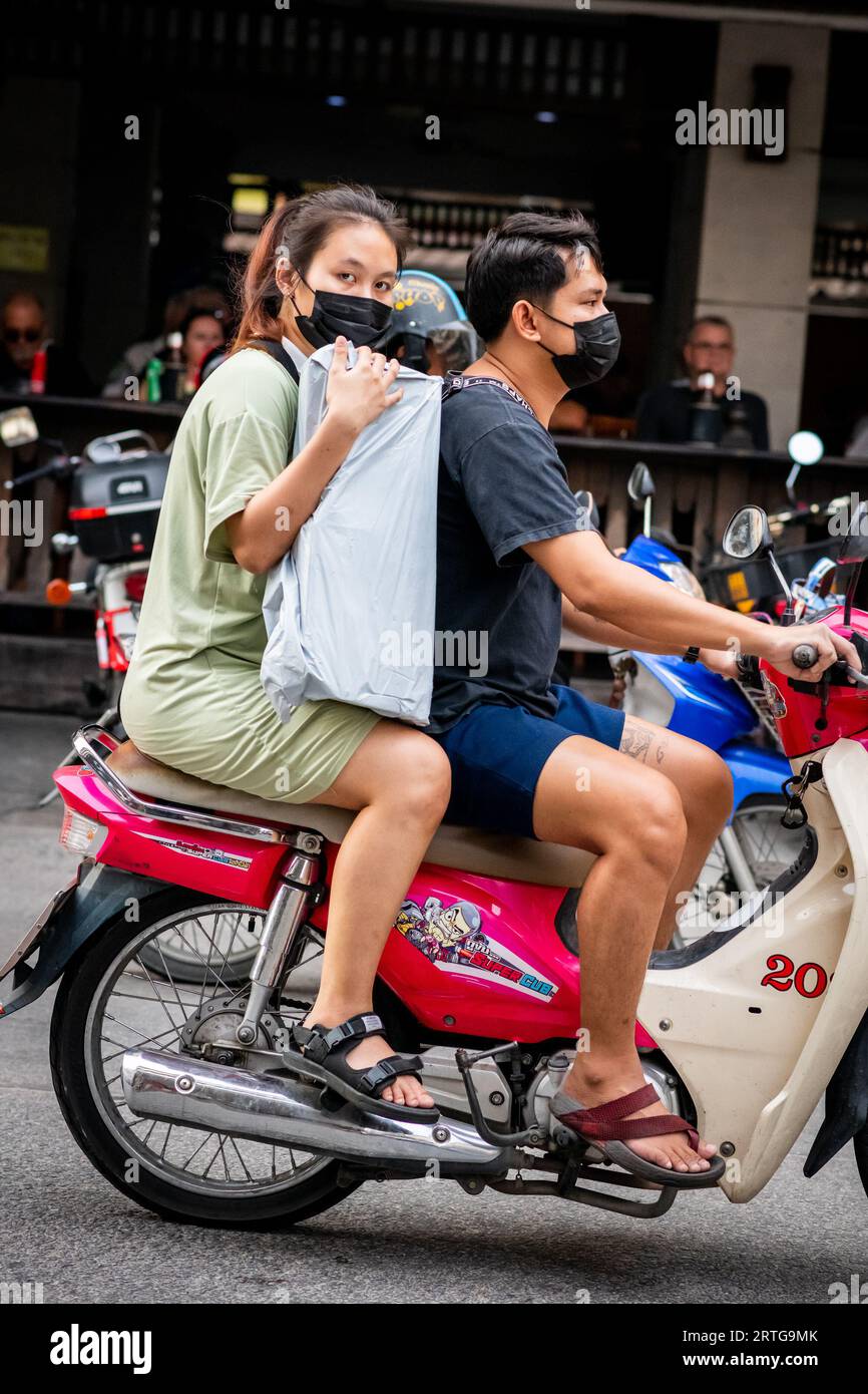 Local Thai people, tourists and residents rush past the busy junction ...