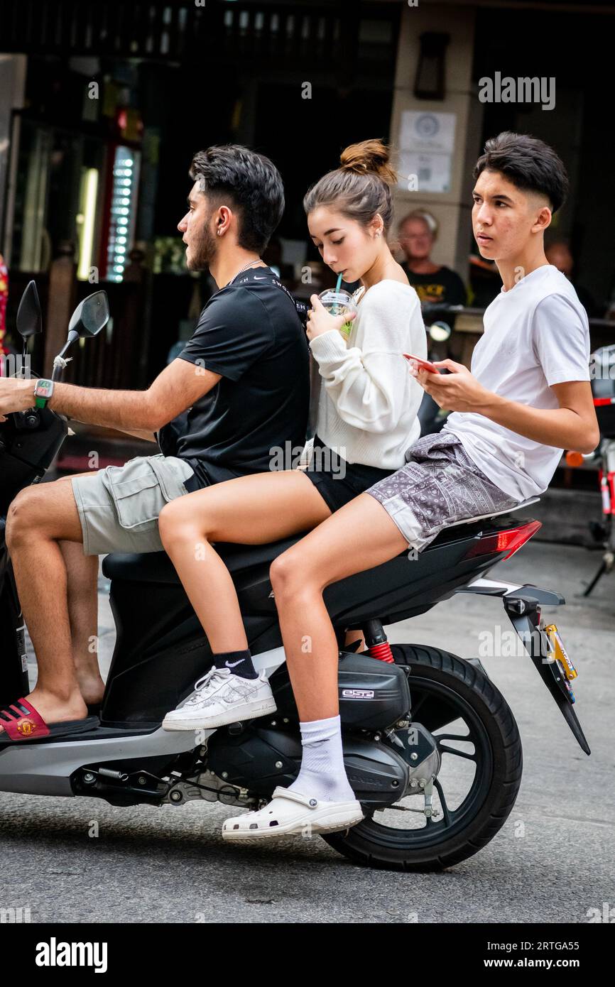 Local Thai people, tourists and residents rush past the busy junction ...