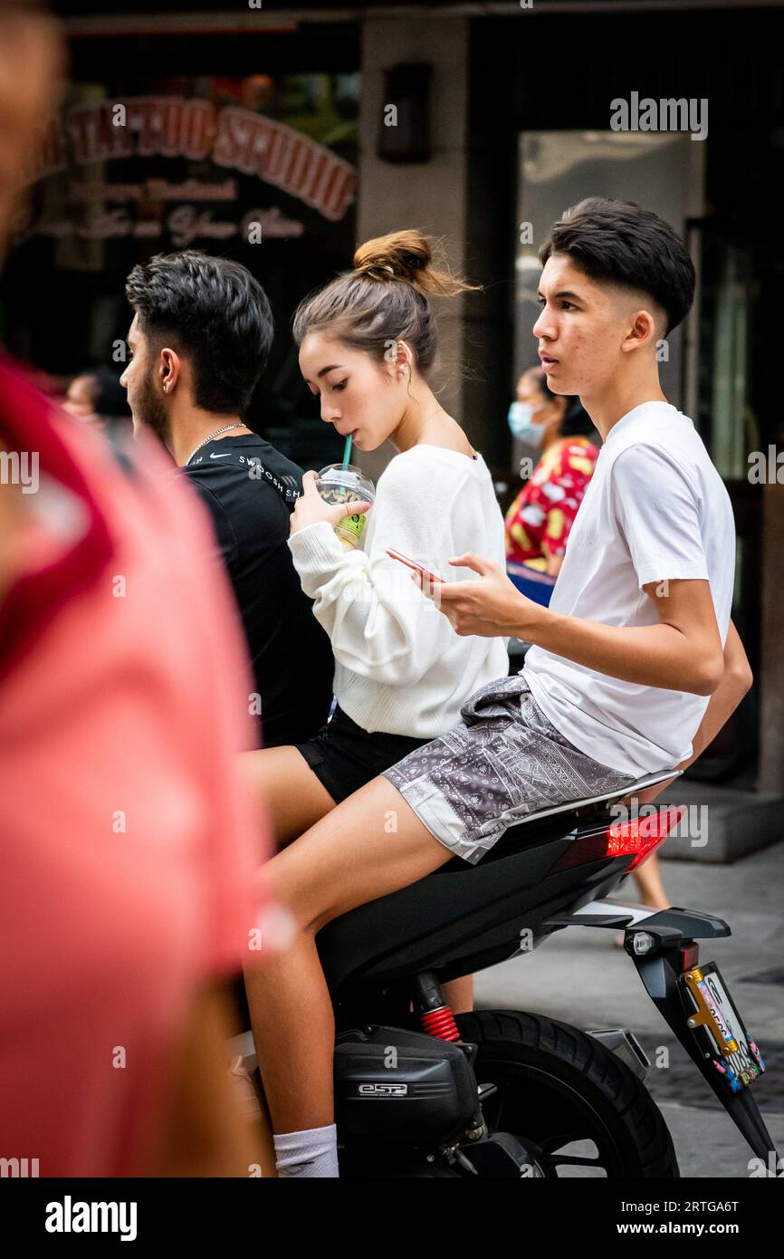 Local Thai people, tourists and residents rush past the busy junction ...