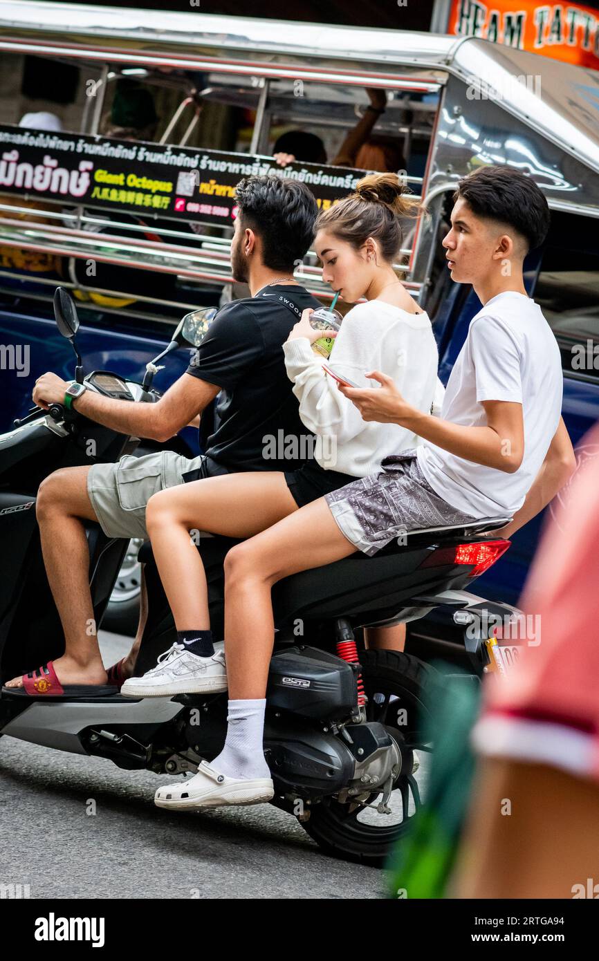 Local Thai people, tourists and residents rush past the busy junction ...