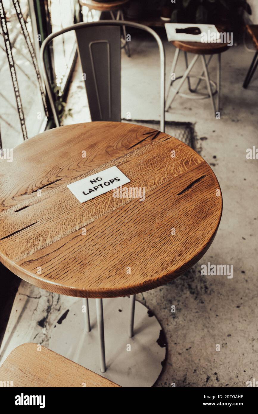 Chairs and wooden table with sign No Laptops. No wi-fi zone in urban ...