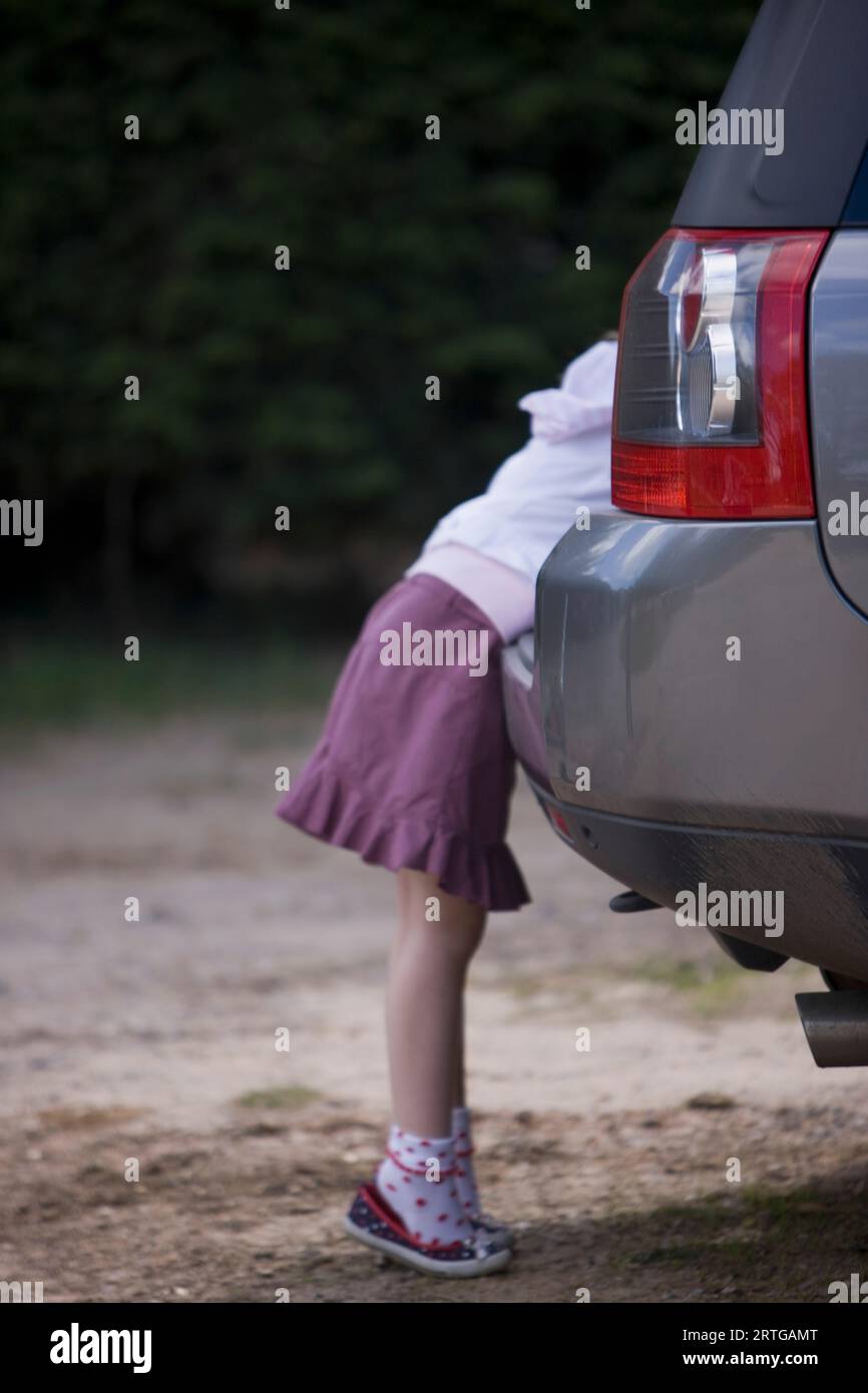 Young girl with looking inside car boot Stock Photo - Alamy