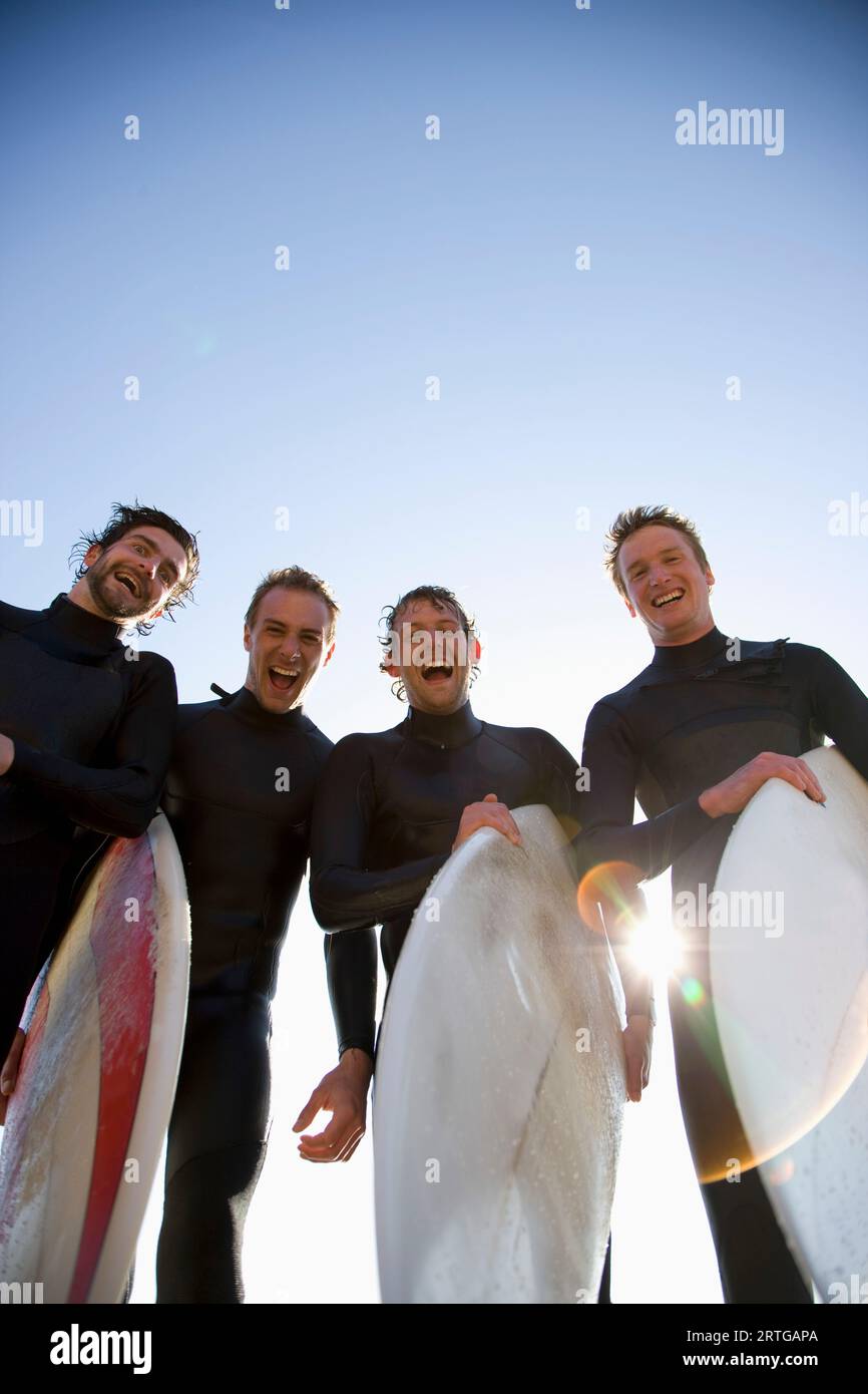 Surfers holding surfboards laughing and screaming Stock Photo - Alamy
