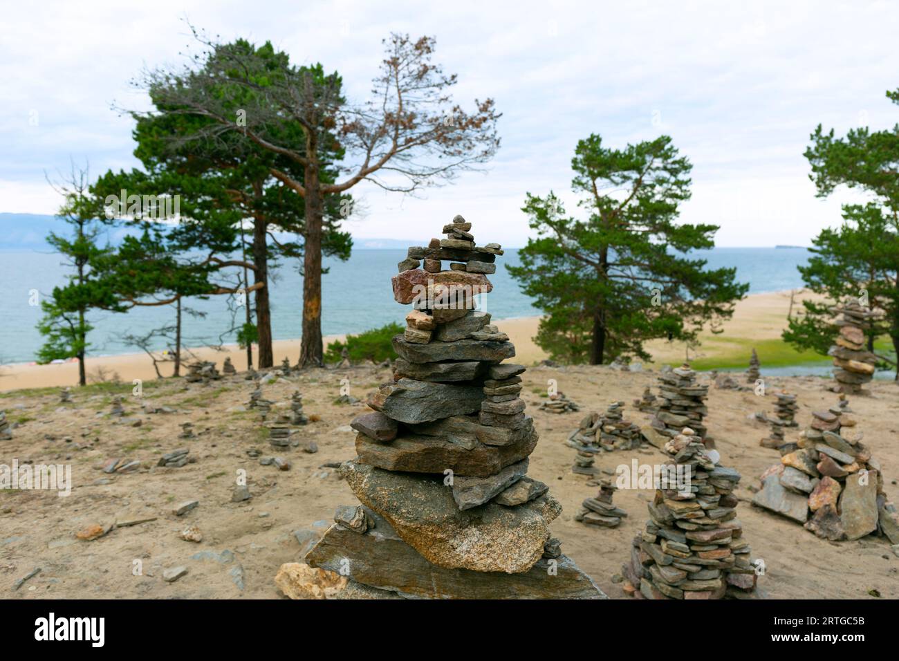 Zen Pyramid Stones and Larches on the Baikal Sand Beach Stock Photo - Alamy