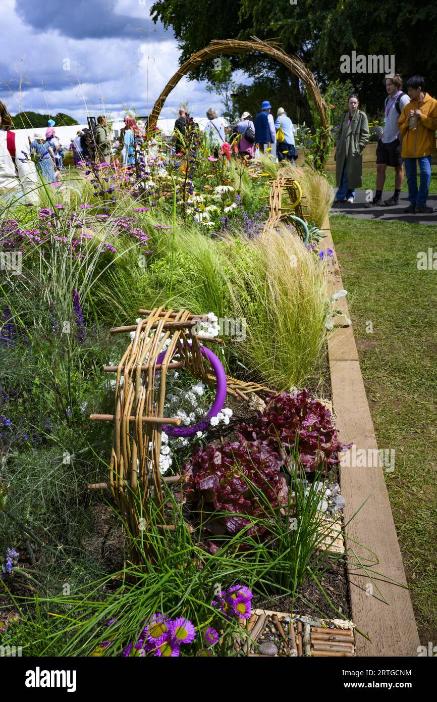 Visitors view colourful garden flowers - horticultural raised bed competition entry, RHS Tatton ...