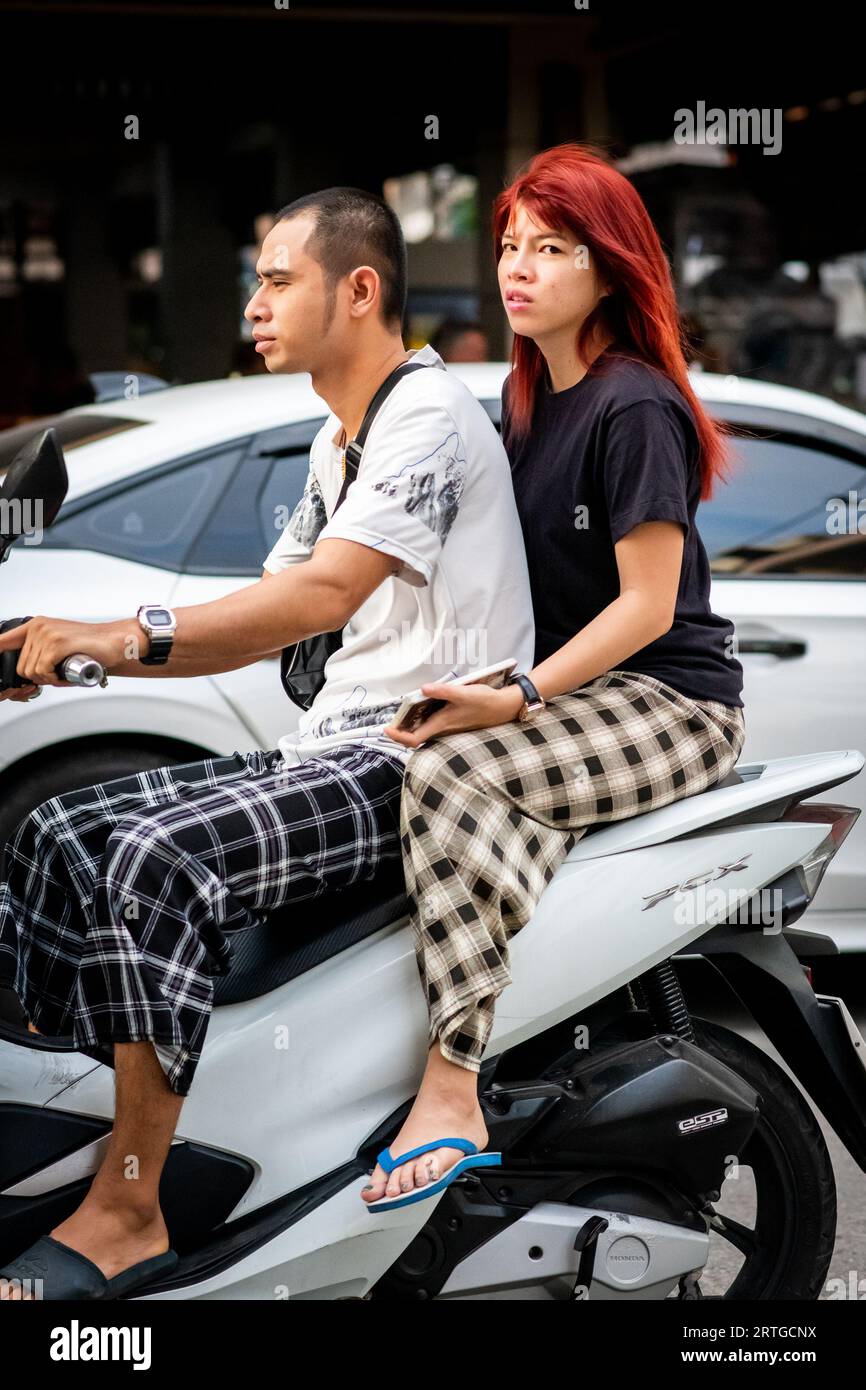 Local Thai people, tourists and residents rush past the busy junction ...