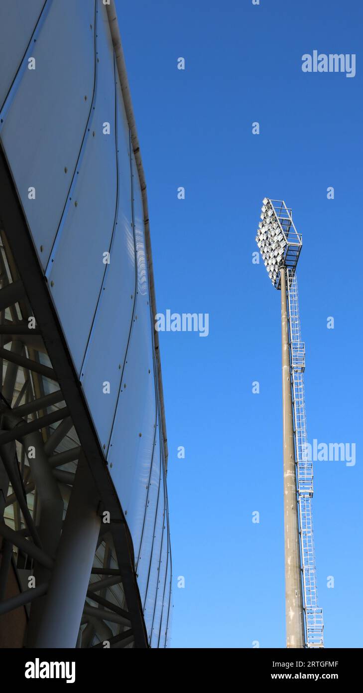 a high floodlight mast and a fragment of the stadium structure against ...