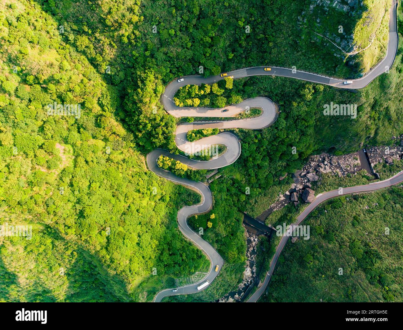 An aerial view of a winding road in a mountain landscape, surrounded by ...