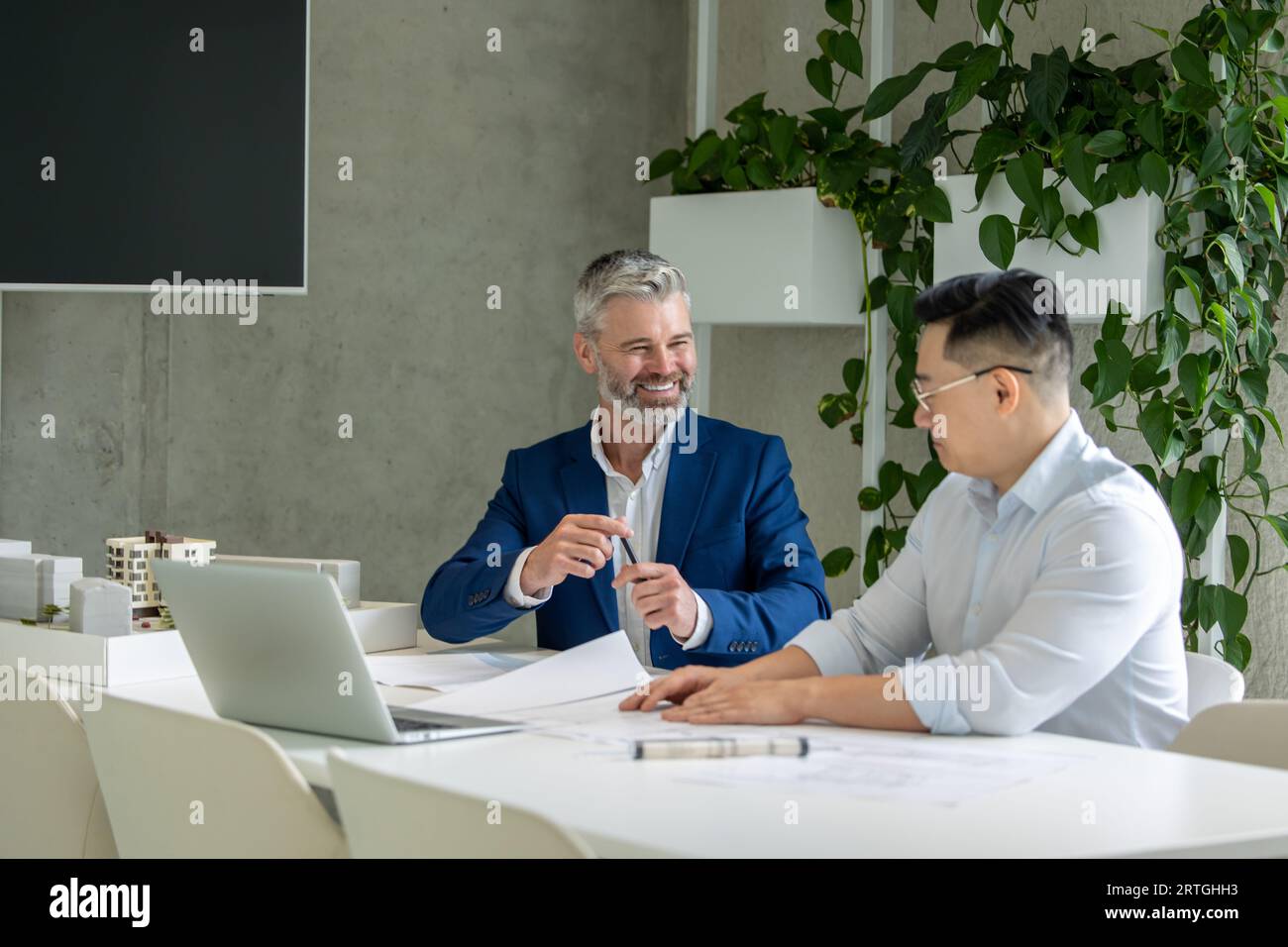 Men architects working on construction plans, engineers discussing on ...
