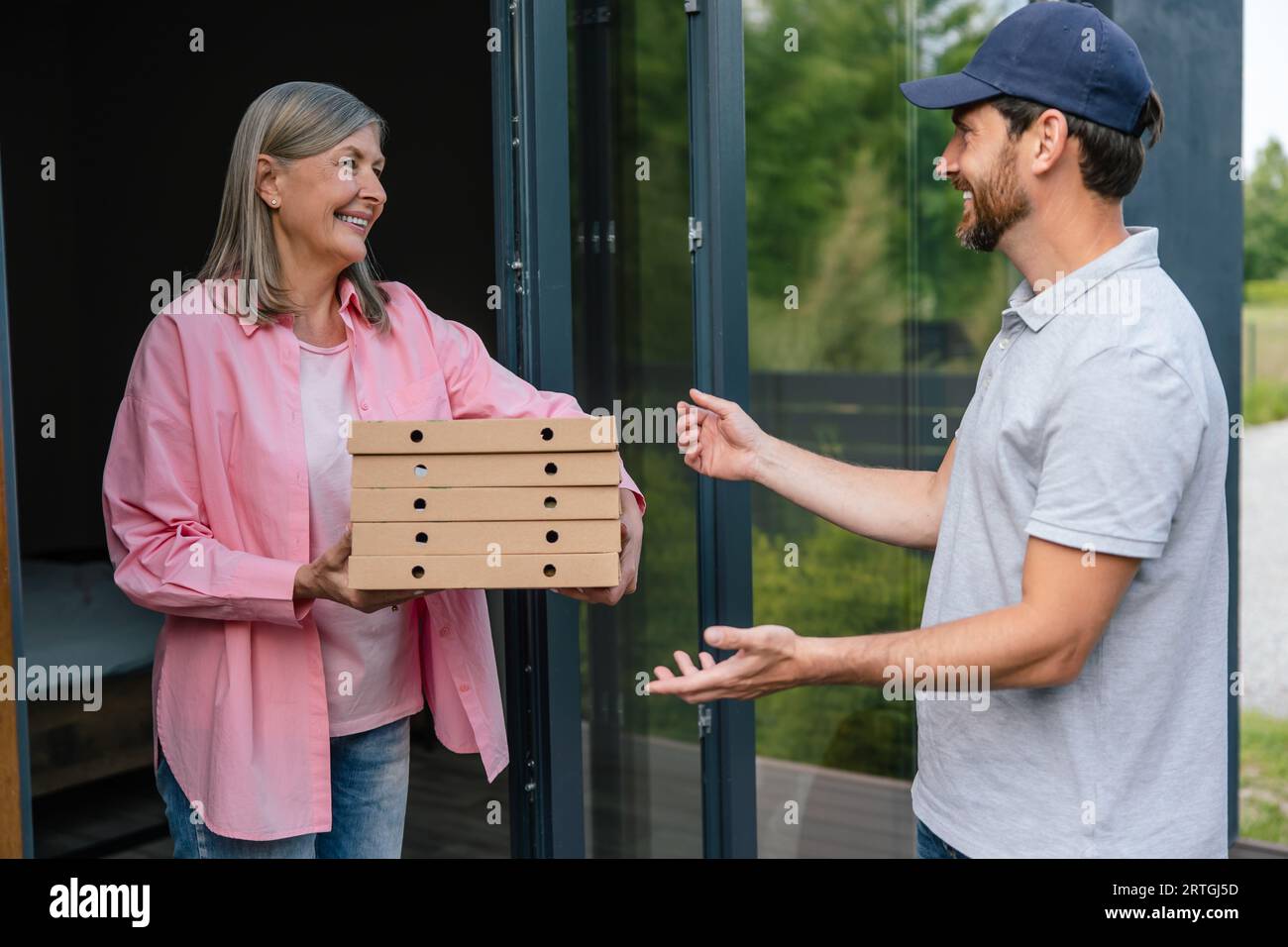Deliver man handling box of pizza give to female costumer Stock Photo ...