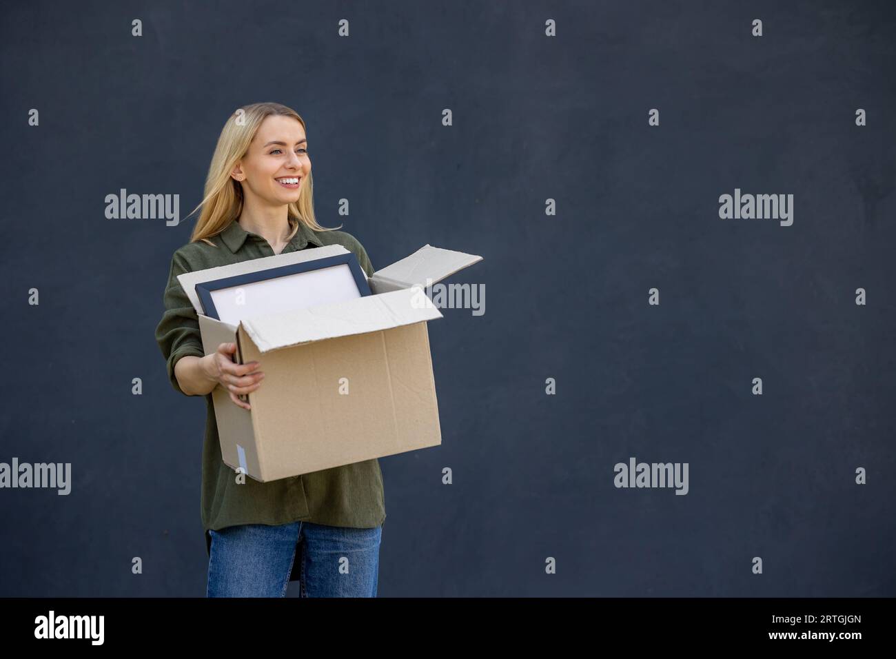 Cute blonde young woman carrying boxes in hands Stock Photo - Alamy